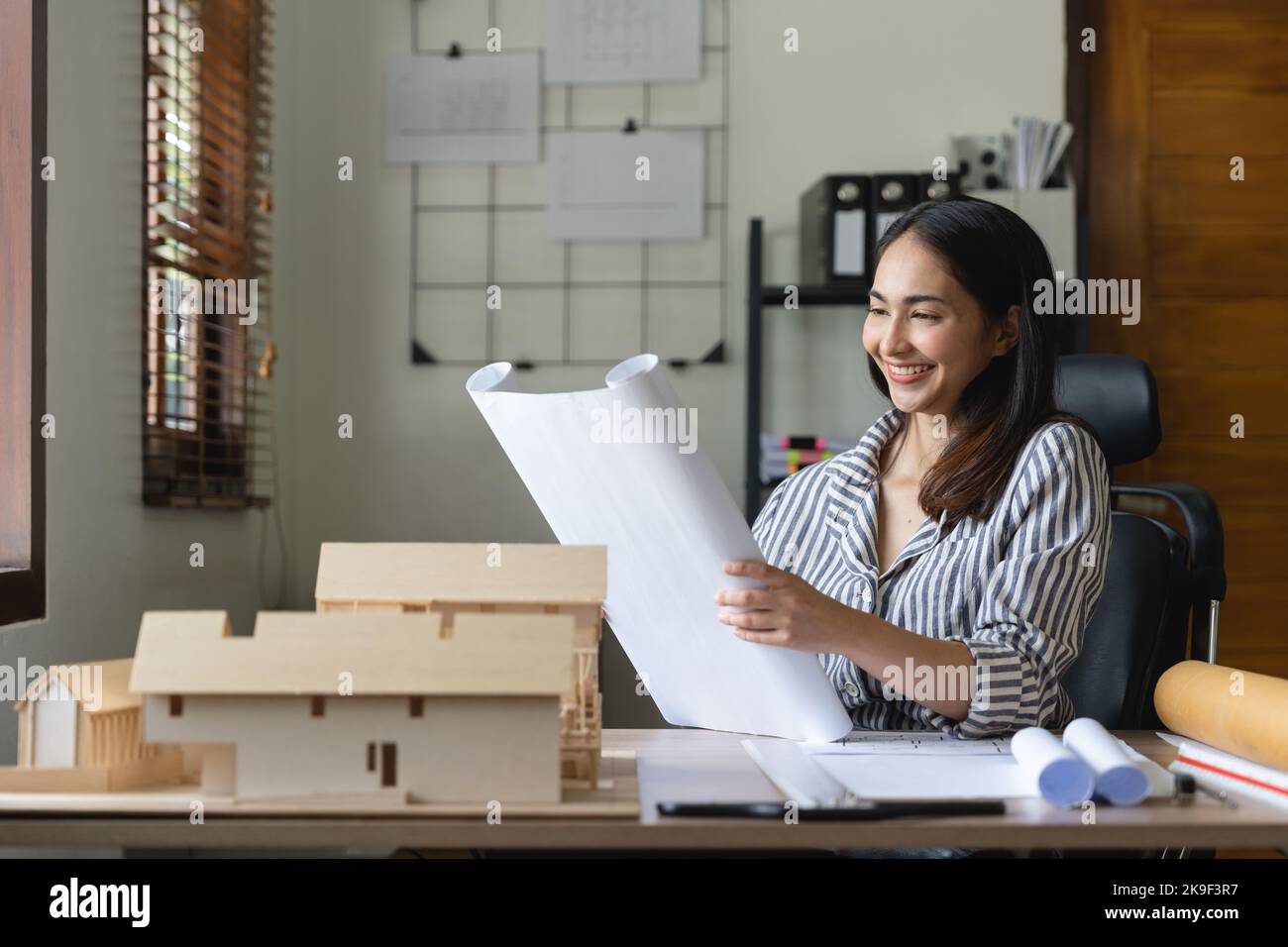 Female asian architect working on blueprint at office Stock Photo - Alamy