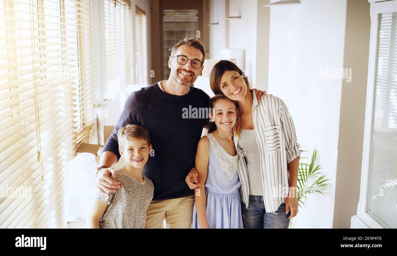 We love our new home to bits. Portrait of a happy family together in ...