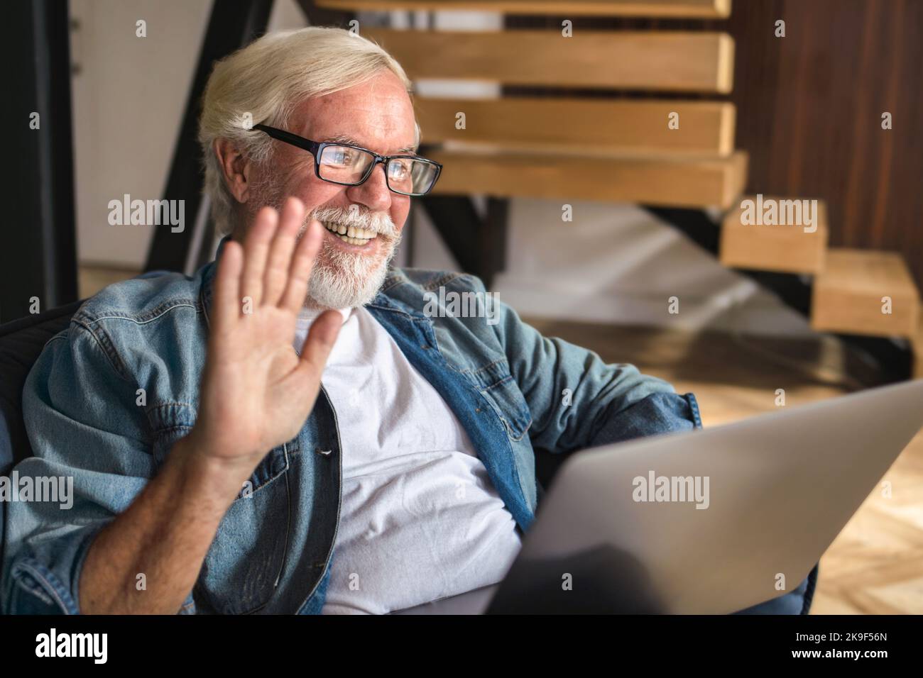 Portrait of happy elderly Caucasian man talking on webcam in video chat ...