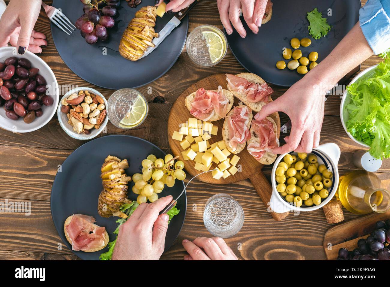 Top view of three people having dinner together on rustic wooden table ...