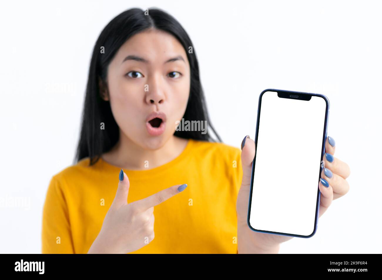 Portrait of young Asian woman with mobile phone on white background ...