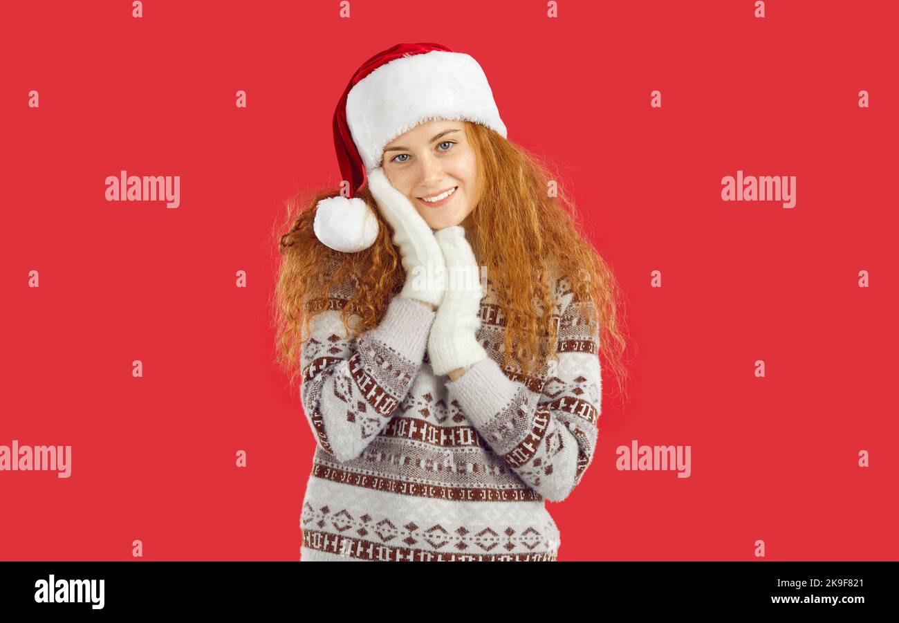 Modest redhead smiling girl in Christmas Santa hat, white mittens and ...