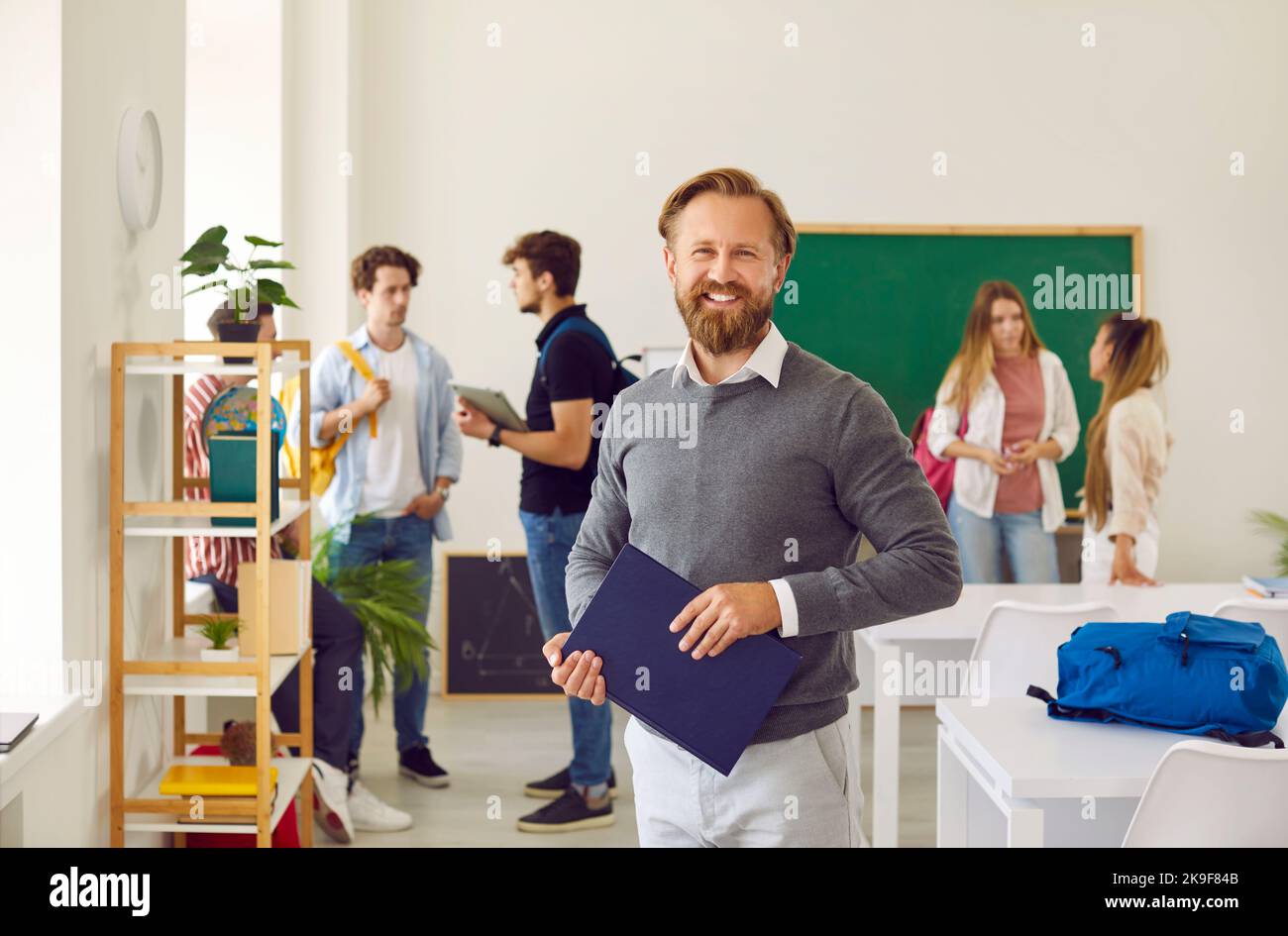Portrait of a happy, smiling school or college teacher standing in the ...