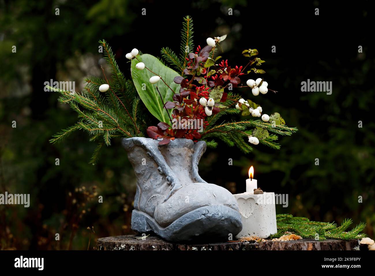 A gray shoe with fir branches and candle stick made of concrete Stock ...