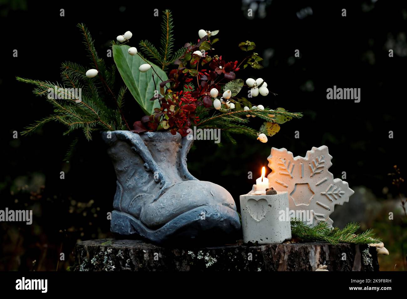 A gray shoe with fir branches and candle stick made of concrete Stock ...