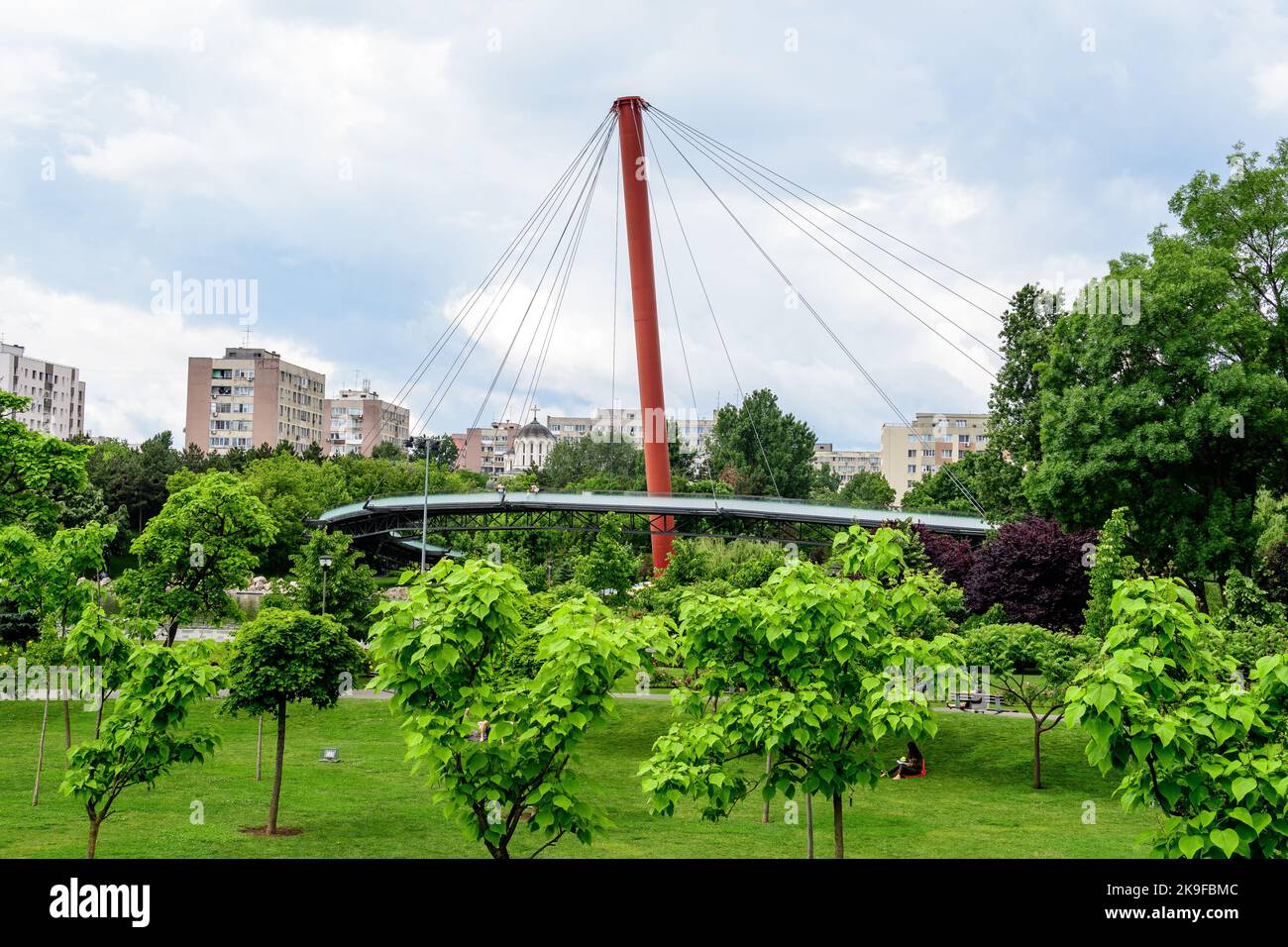 Landscape with the modern red metallic bridge and vivid green grass and ...