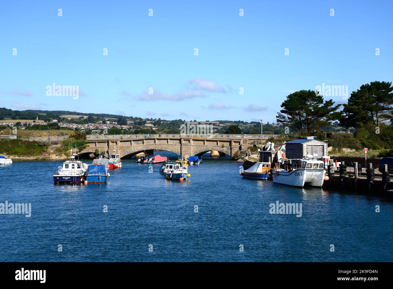 Bridge across the River Axe with small fishing boats in the foreground ...