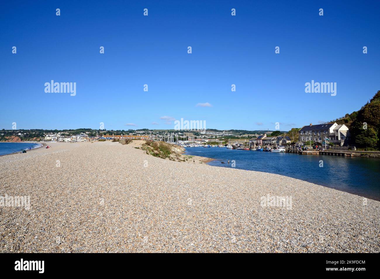 Fishing boats and yachts moored along the River Axe in the harbour with ...