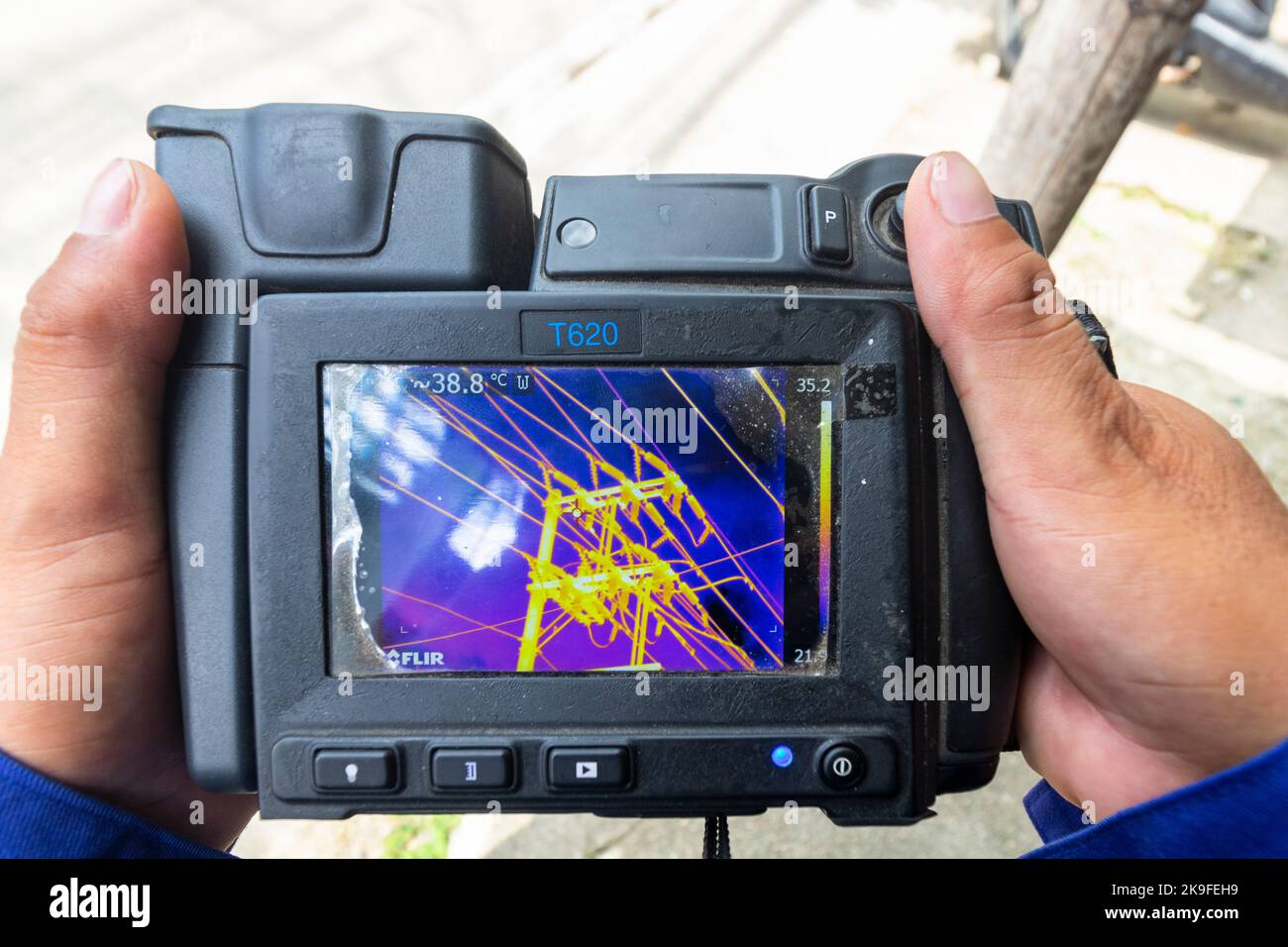 A Filipino electric utility worker using a thermal camera to check a ...