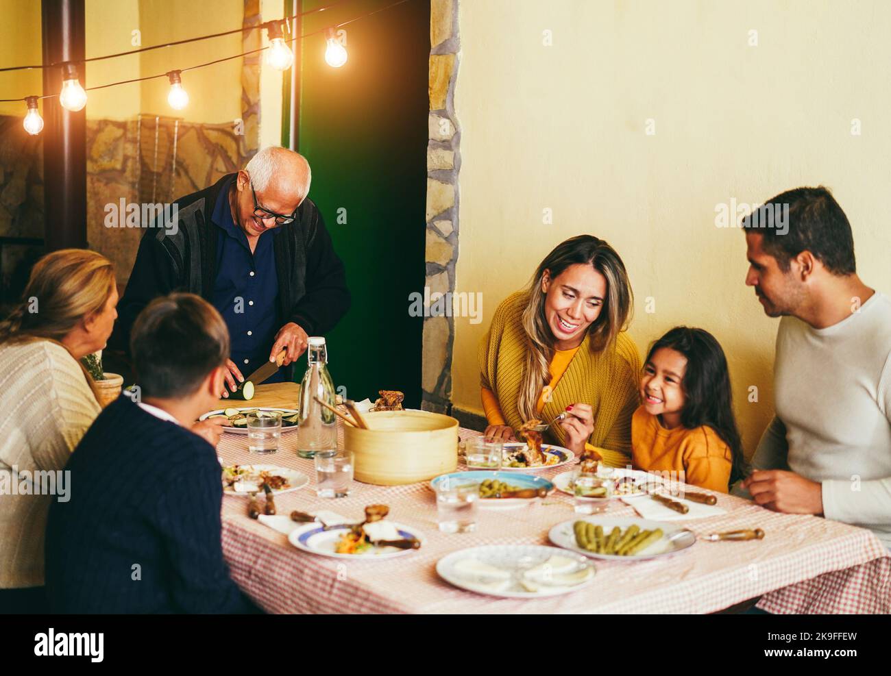 Happy latin family cooking together during dinner time at home - Focus ...
