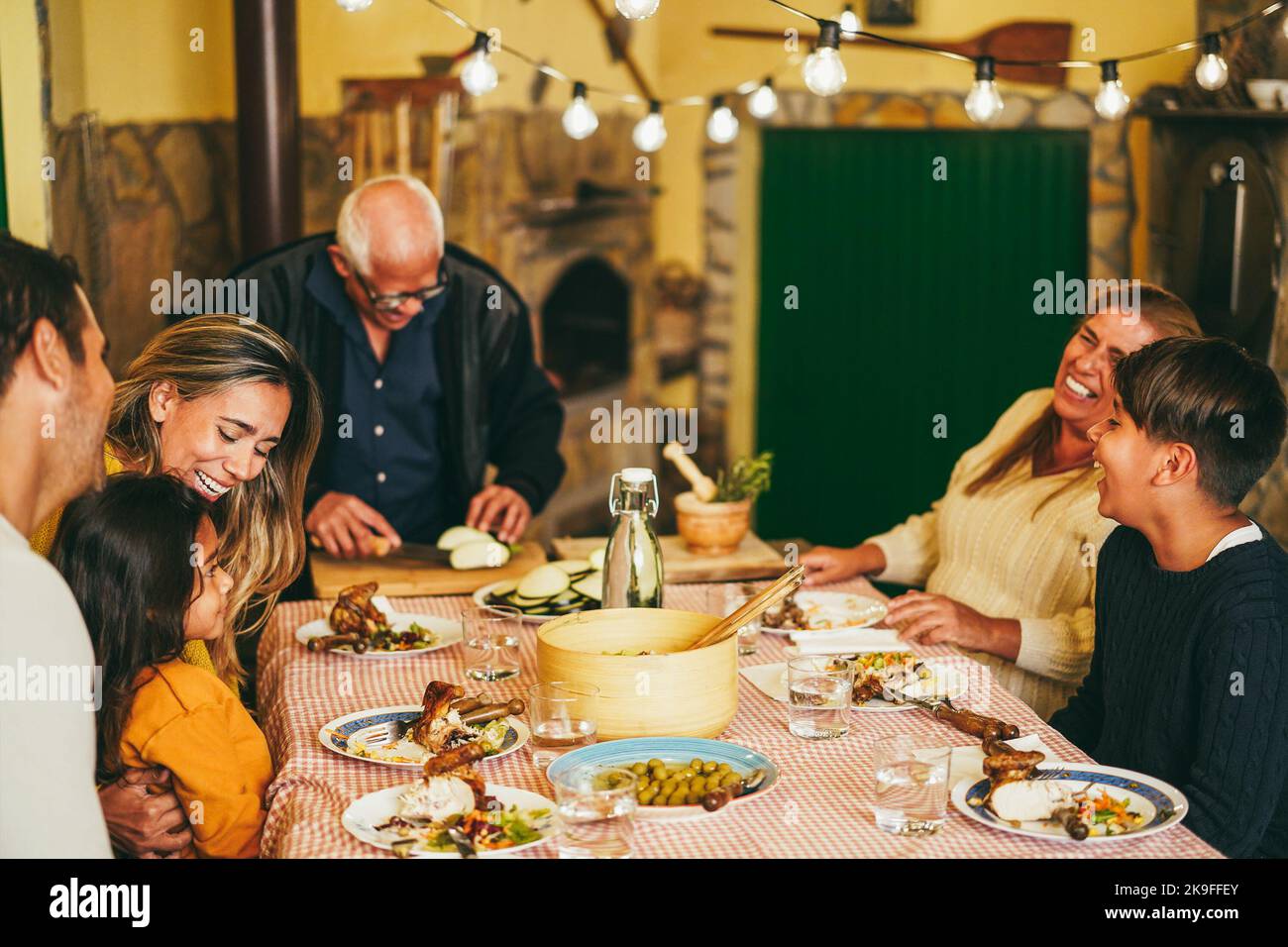 Happy latin family cooking together during dinner time at home - Focus ...