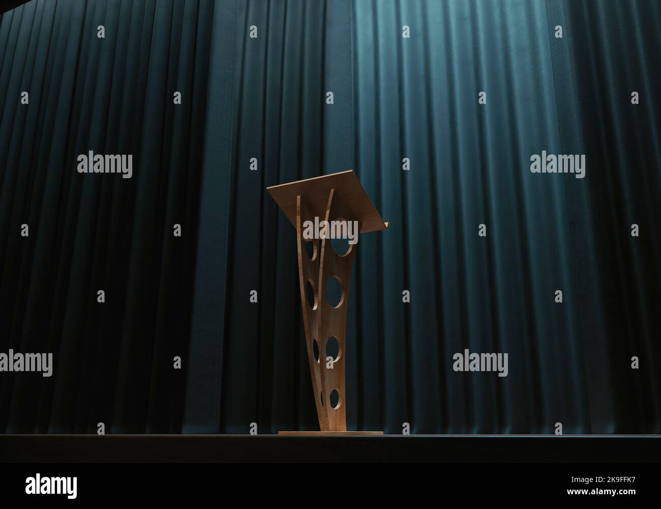 A wooden speech podium with small microphones on a dark curtained stage ...