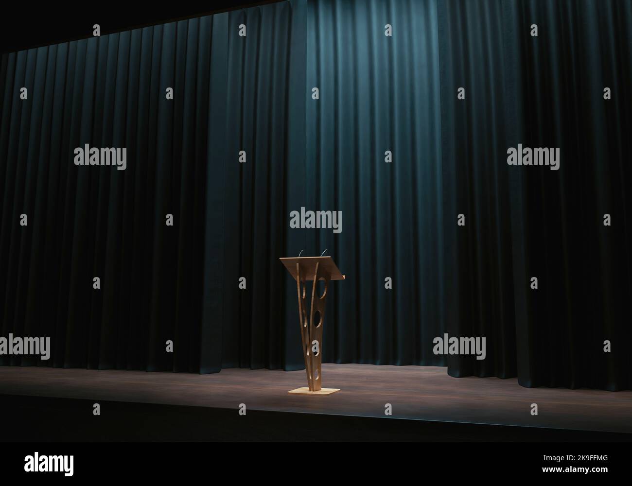 A wooden speech podium with small microphones on a dark curtained stage ...