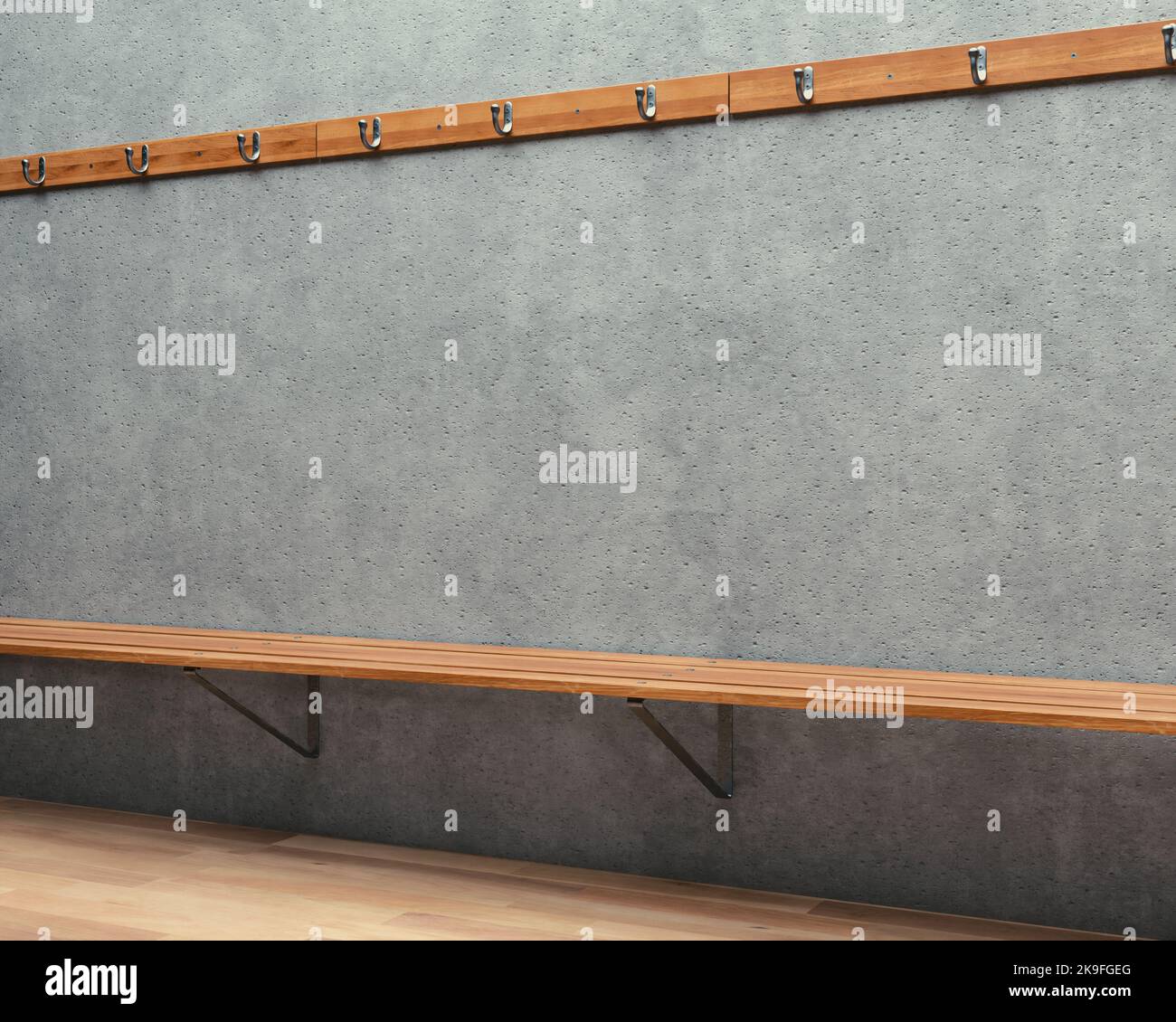 A clothes hanging rack above an empty wooden bench against a concrete ...