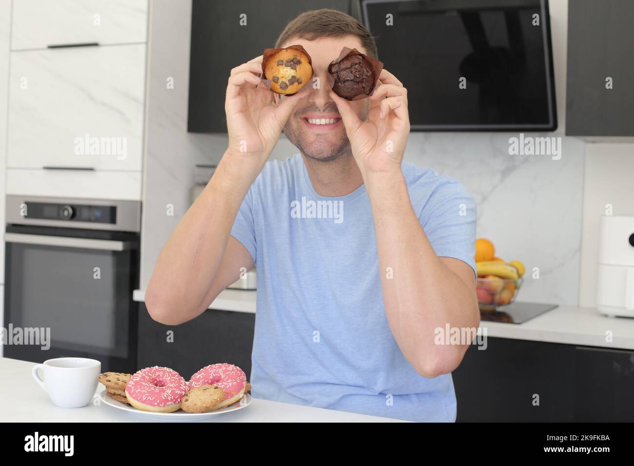 Man with muffins covering eyes Stock Photo - Alamy