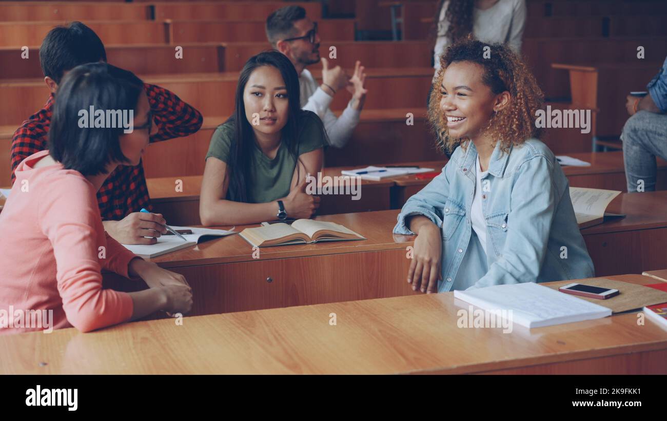 Young women students are having conversation after lectures at college ...