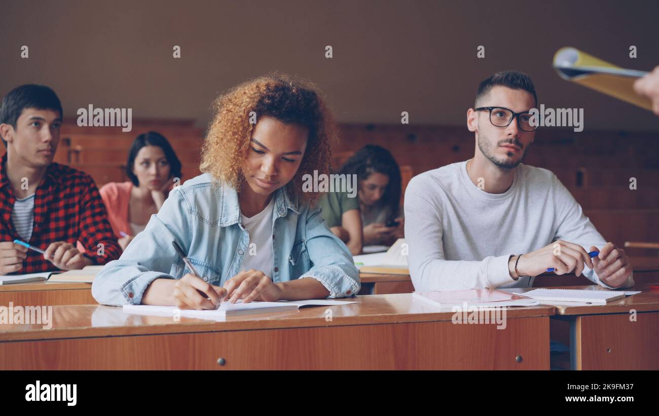 Smart guy in glasses diligent student is talking to teacher sitting at ...