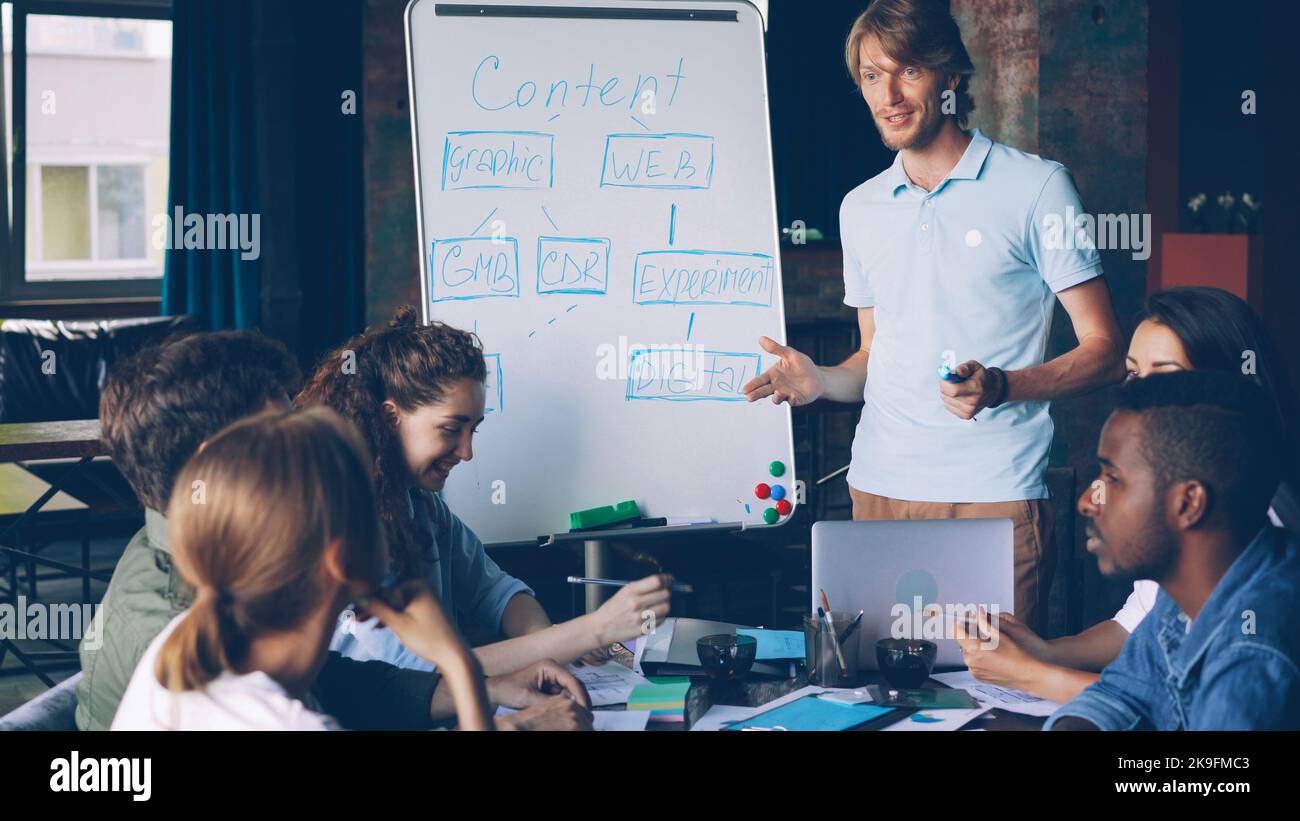 Creative manager is using whiteboard at business meeting in office ...