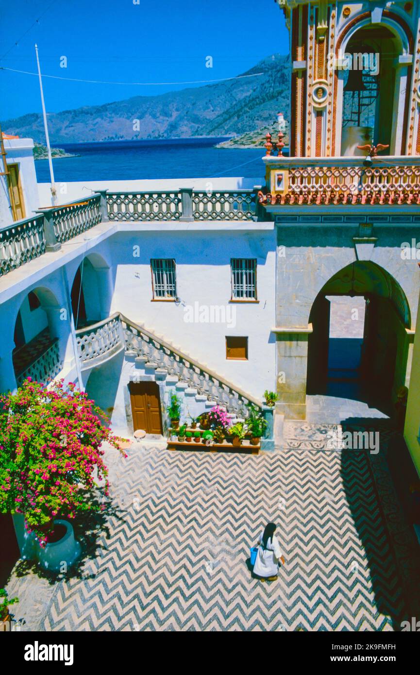 Monastery of Archangel Michael Panormitis on Greece, Symi island. Woman ...