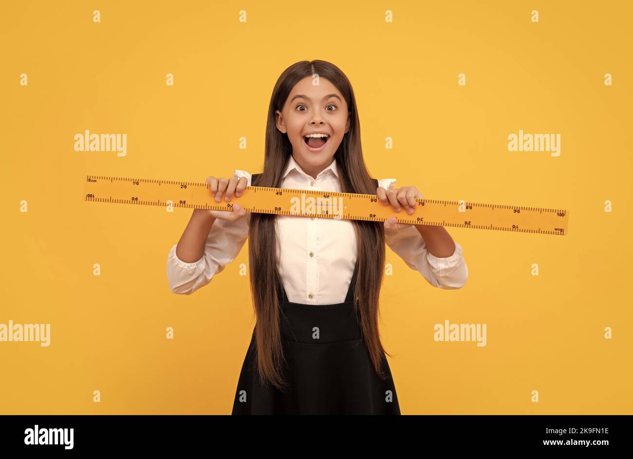 amazed kid in school uniform hold mathematics ruler for measuring ...