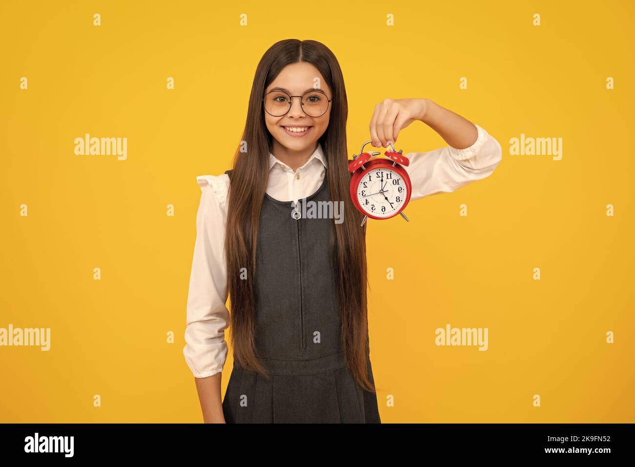 Happy girl face, positive and smiling teen girl holding clock over ...