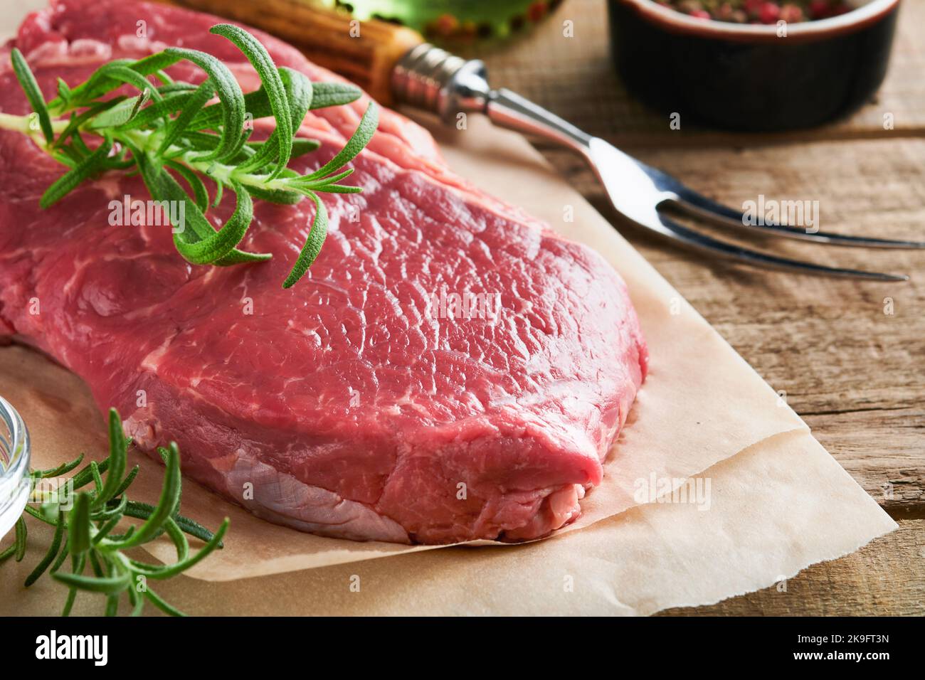 Raw beef steak. Fresh beef rib eye steak with fork rosemary, salt and ...