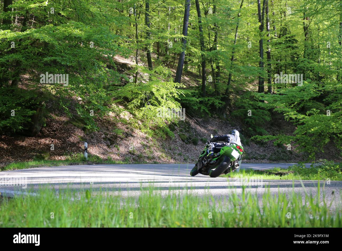 Sporty motorcyclist photographed from behind Stock Photo - Alamy