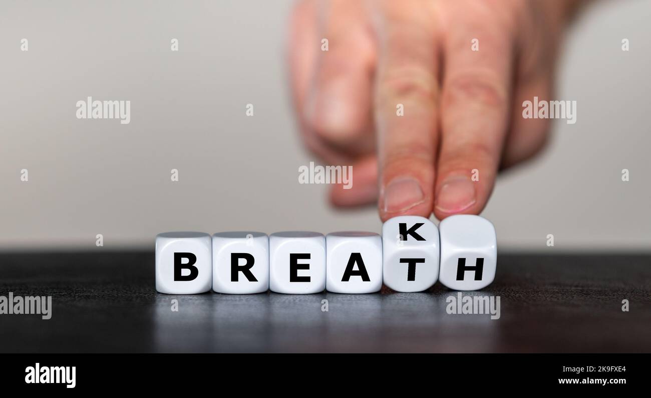Hand turns dice and changes the word breath to break Stock Photo - Alamy