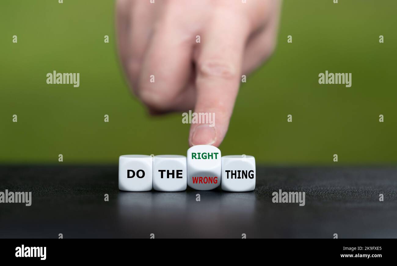 Hand turns dice and changes the expression 'do the wrong thing' to 'do the right thing' Stock ...