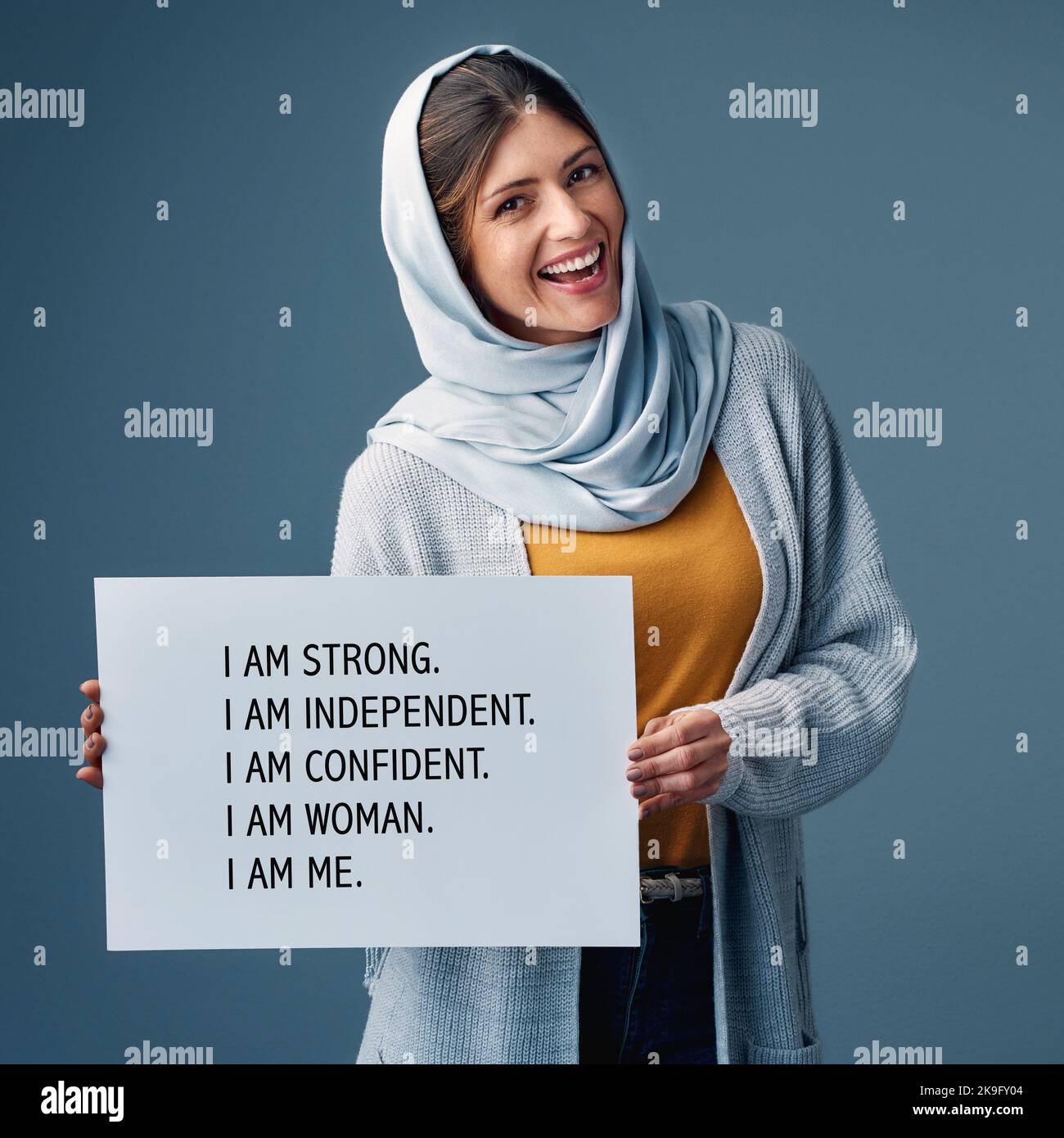 I am me. Studio portrait of an attractive young woman holding up a sign ...