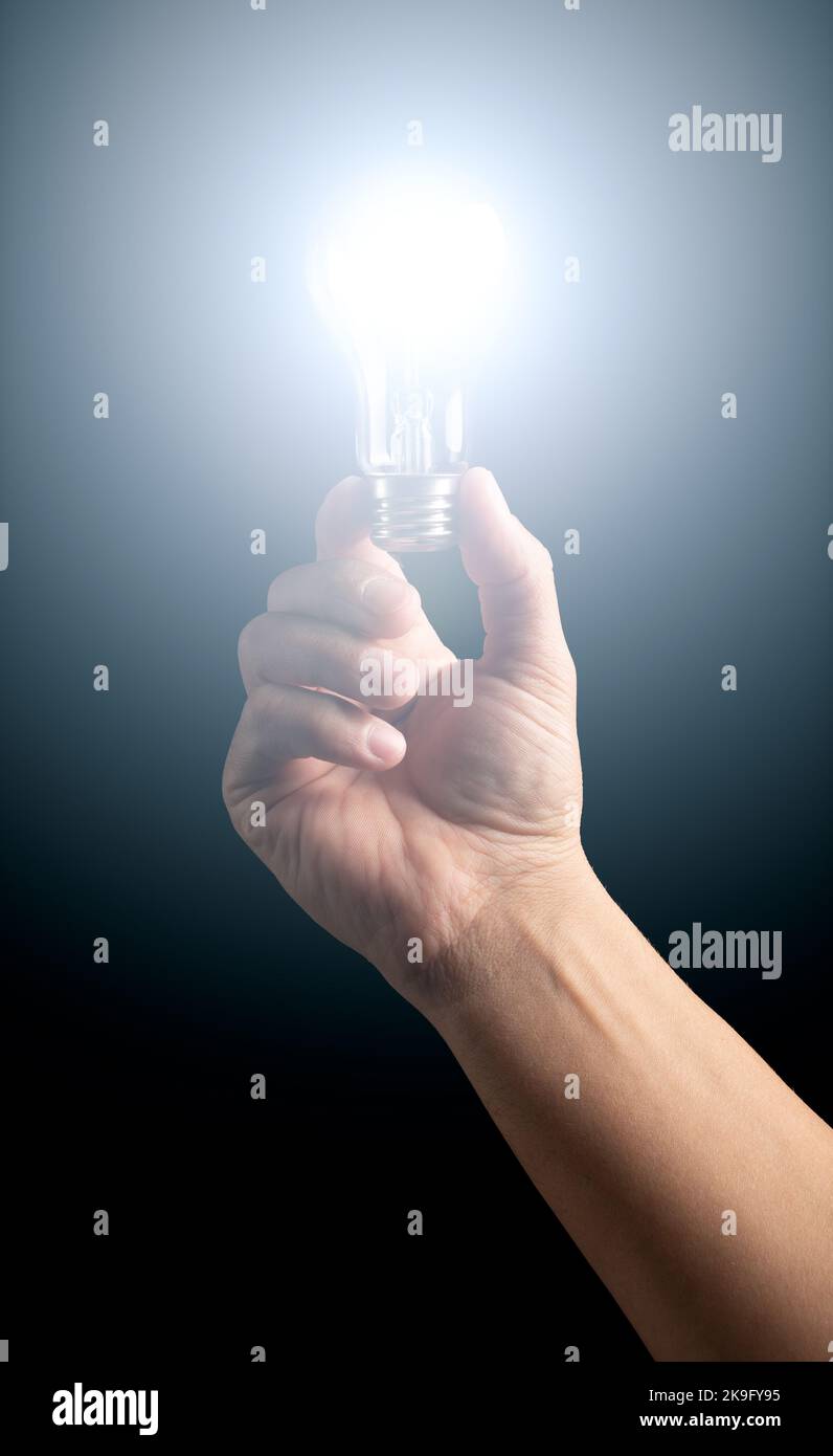 Man's hand holding lighted light bulb Stock Photo - Alamy