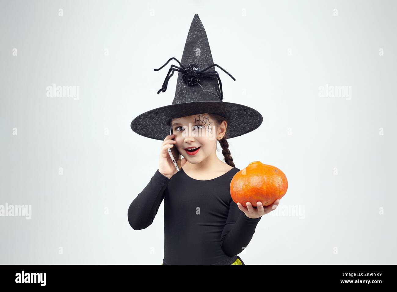 charming little girl in a witch costume talks on her smartphone Stock ...