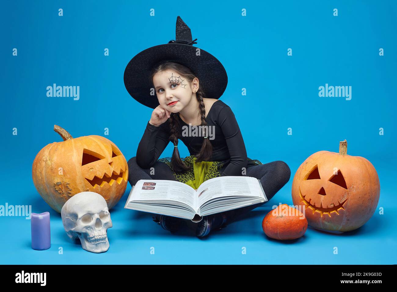 charming little girl in a witch costume conjures Jack's lantern in ...