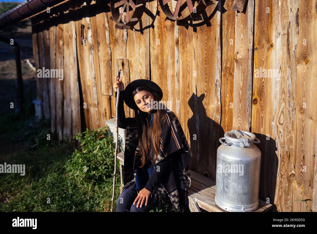 Woman sits on a bench with milk cans on a farm Stock Photo - Alamy