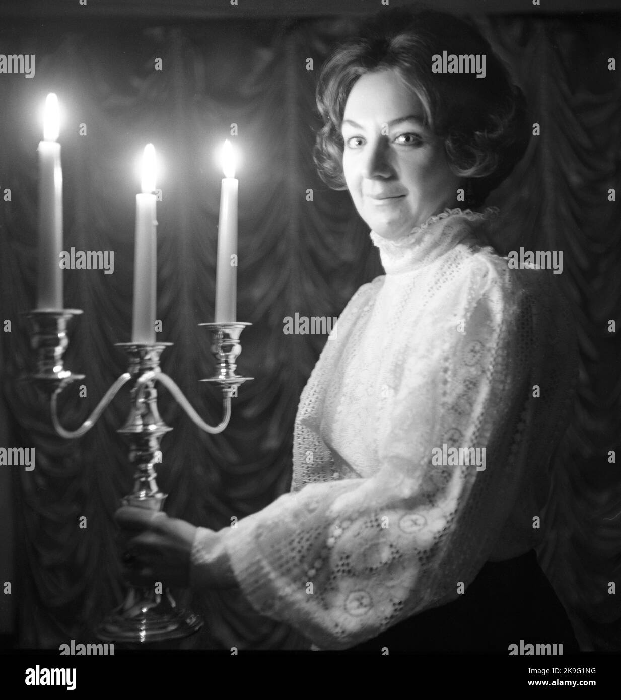A woman in 19th century clothing walking by candlelight by Gilbert ...