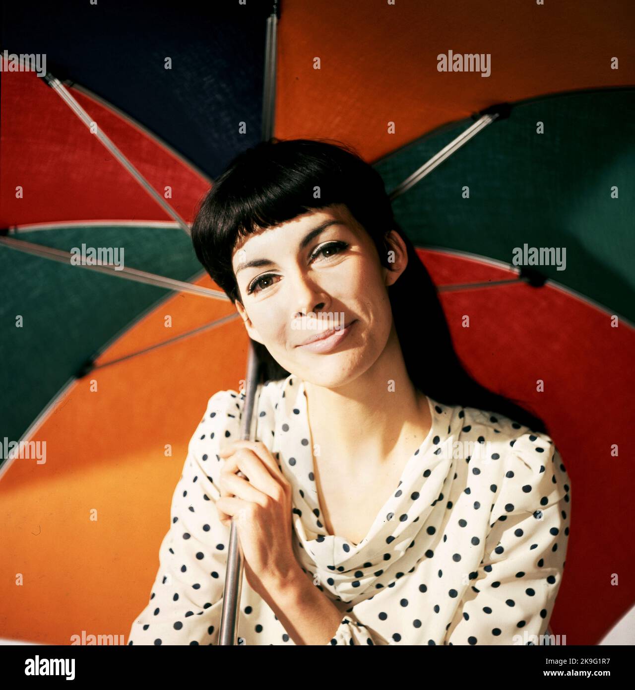 Fringed slim woman smiling with colourful umbrella c1969 by Gilbert ...