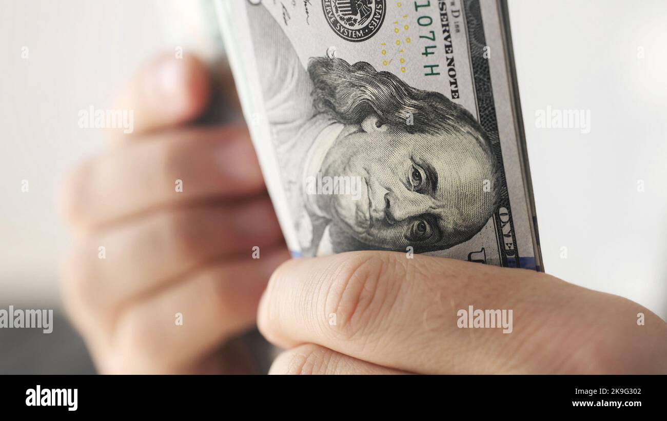 Man counting american dollars banknotes Stock Photo - Alamy
