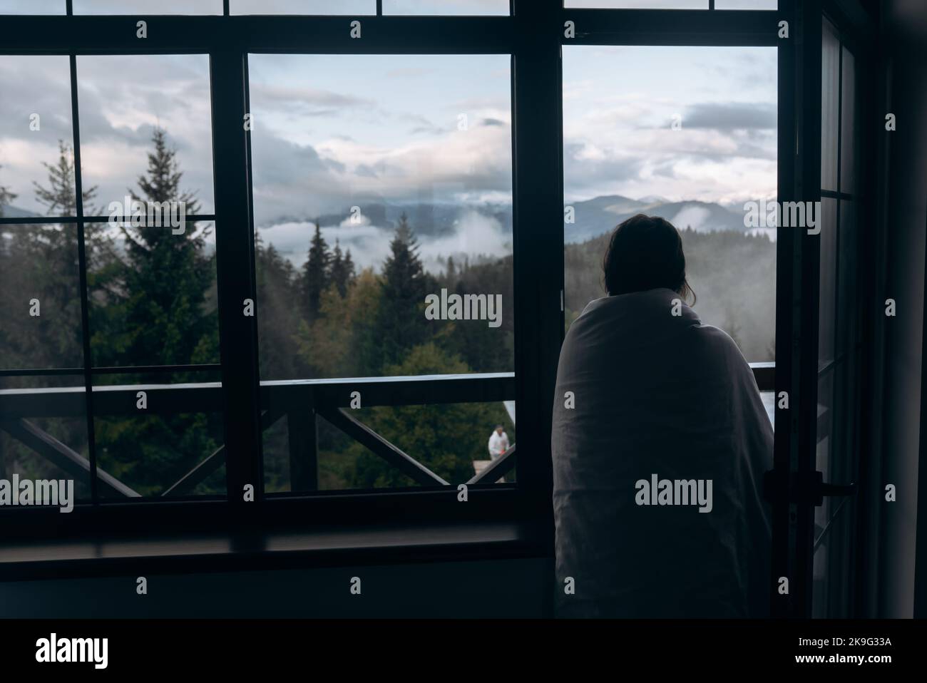 Young woman is looking through the window at the mountains Stock Photo ...