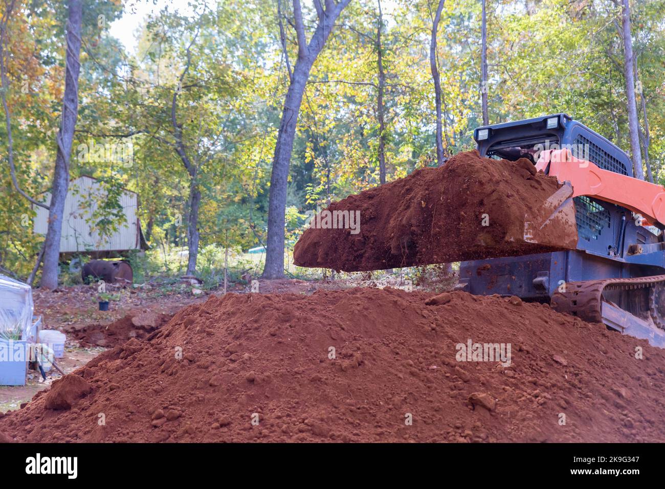On construction site small tractor is used to move soil to create ...
