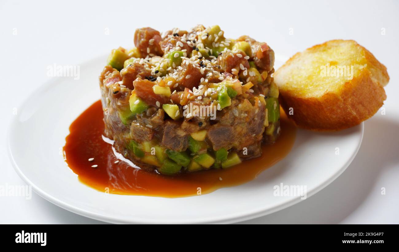 Raw Fish tartar from tuna fillet with hashed avocado, with spices, lime ...