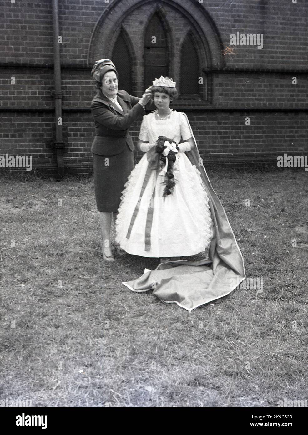 1962, historical, a lady adjusting the crown on the head of a young ...