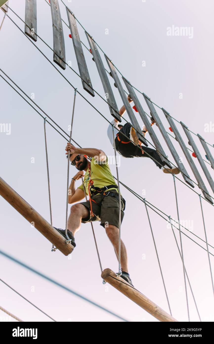 Two strong and athletic boys doing the hardest course in the adventure ...