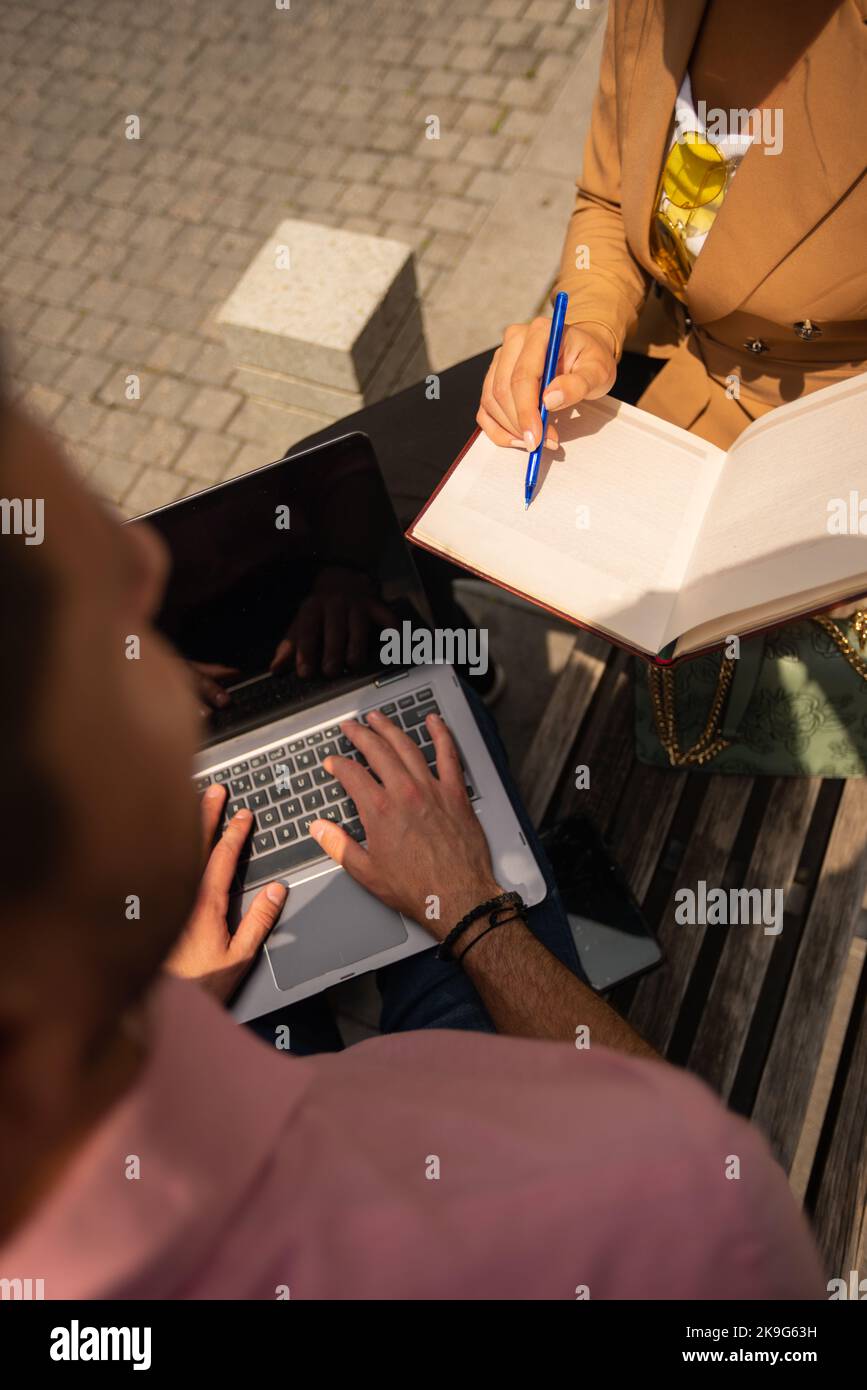 Two business people are working hard on their business project, sitting ...