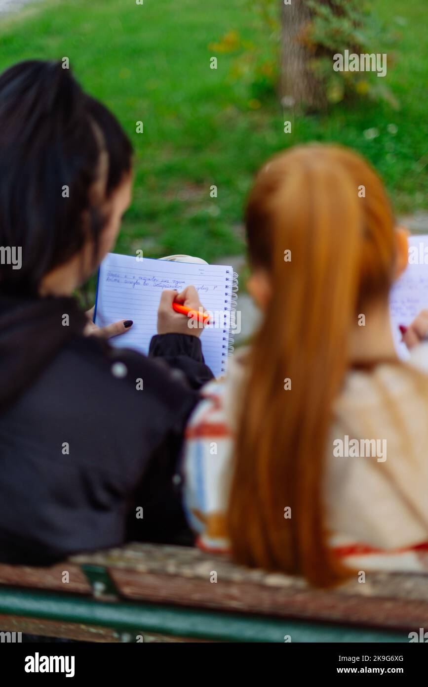 Female high school friends writing their homework together Stock Photo ...