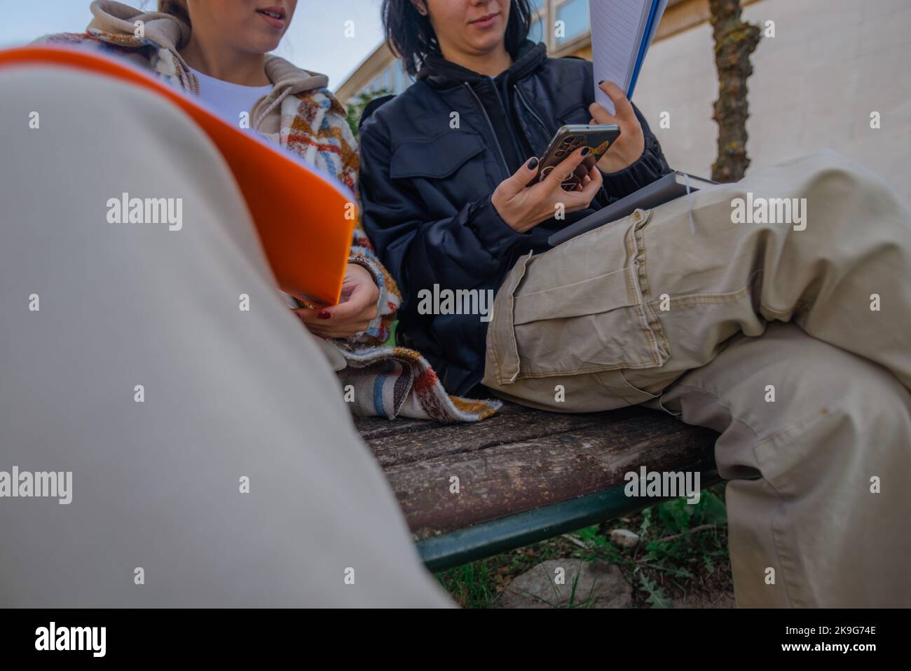 A high school teenager with black hair is checking her phone up, her ...