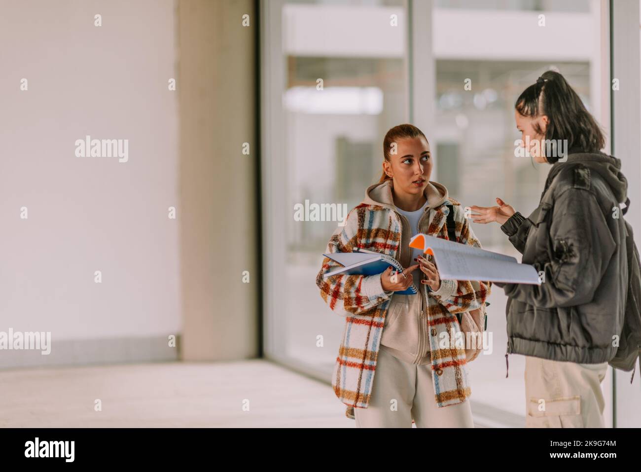 Two high school having a serious conversation in the school's hall on a ...