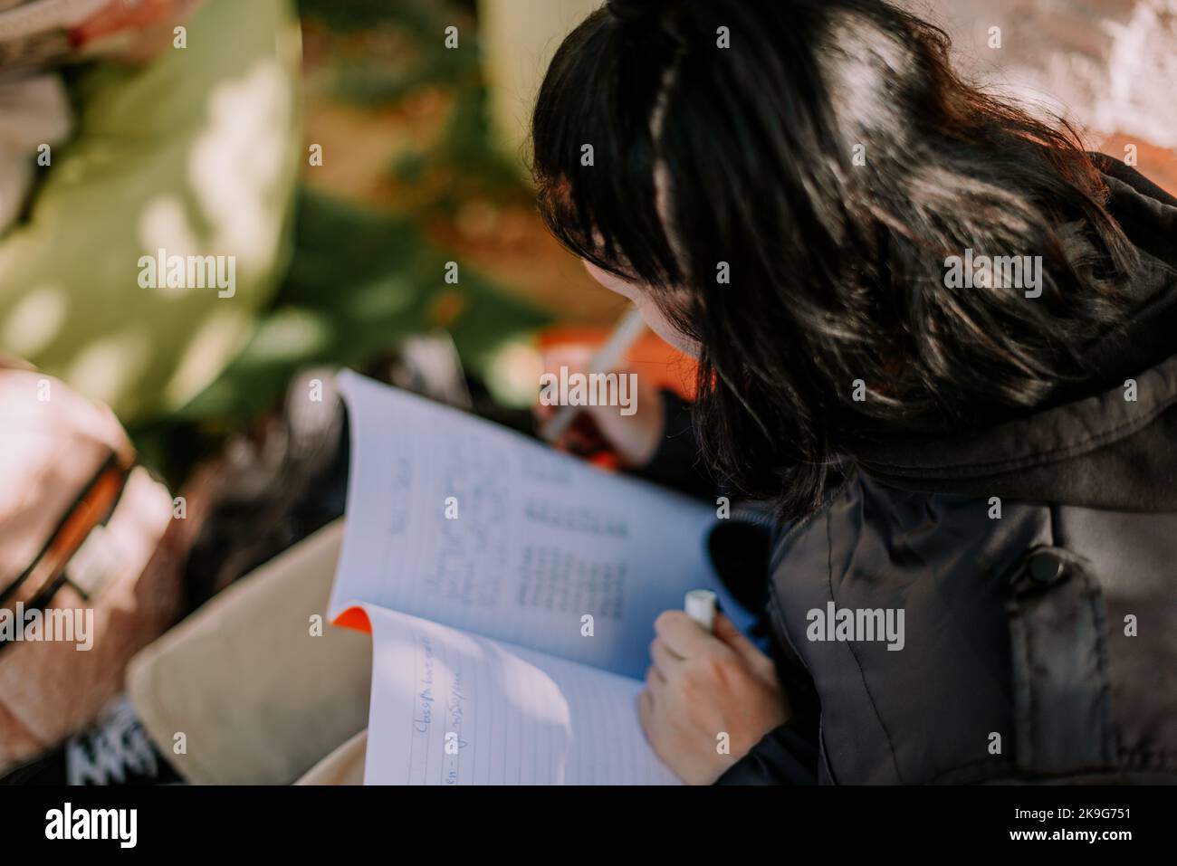 Female student doing her homework outside, after school Stock Photo - Alamy