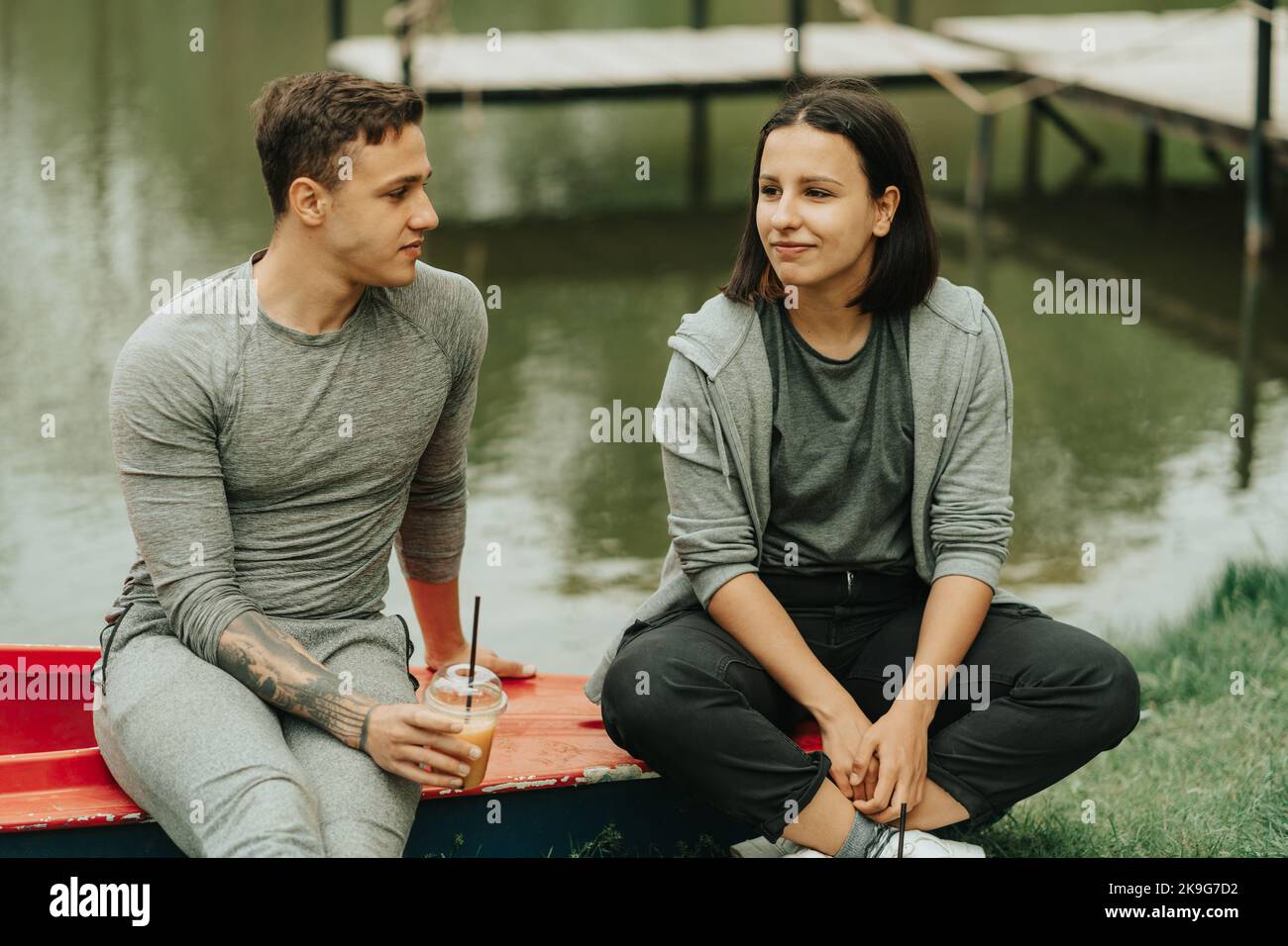 Cute couple sitting on a kayak in the park drinking orange juice Stock ...