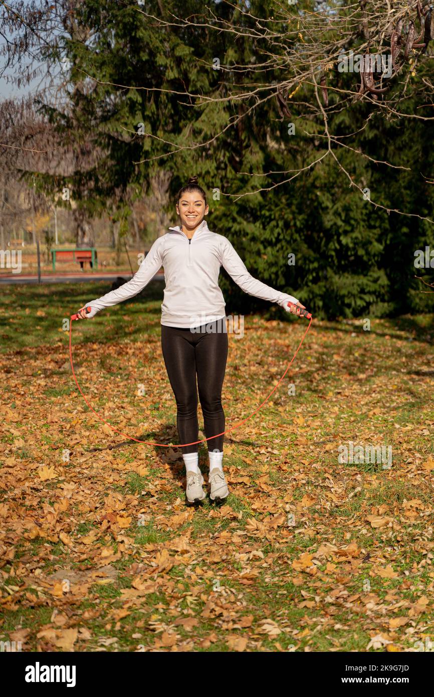 Attractive and beautiful fit girl is jumping on rope and smiling Stock ...