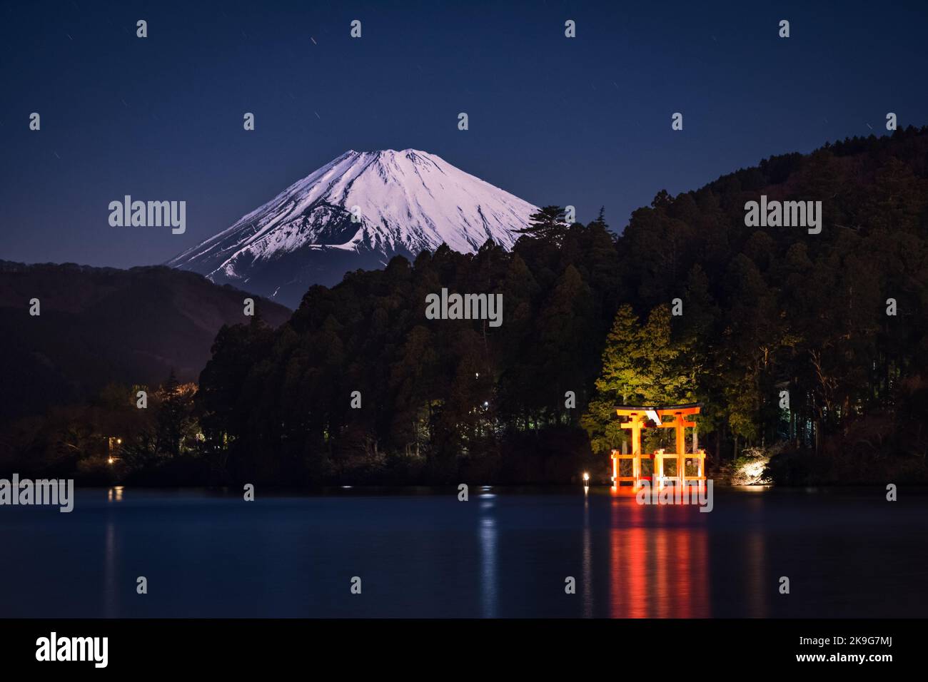 The breathtaking view of the snowy mount Fuji behind the illuminated ...